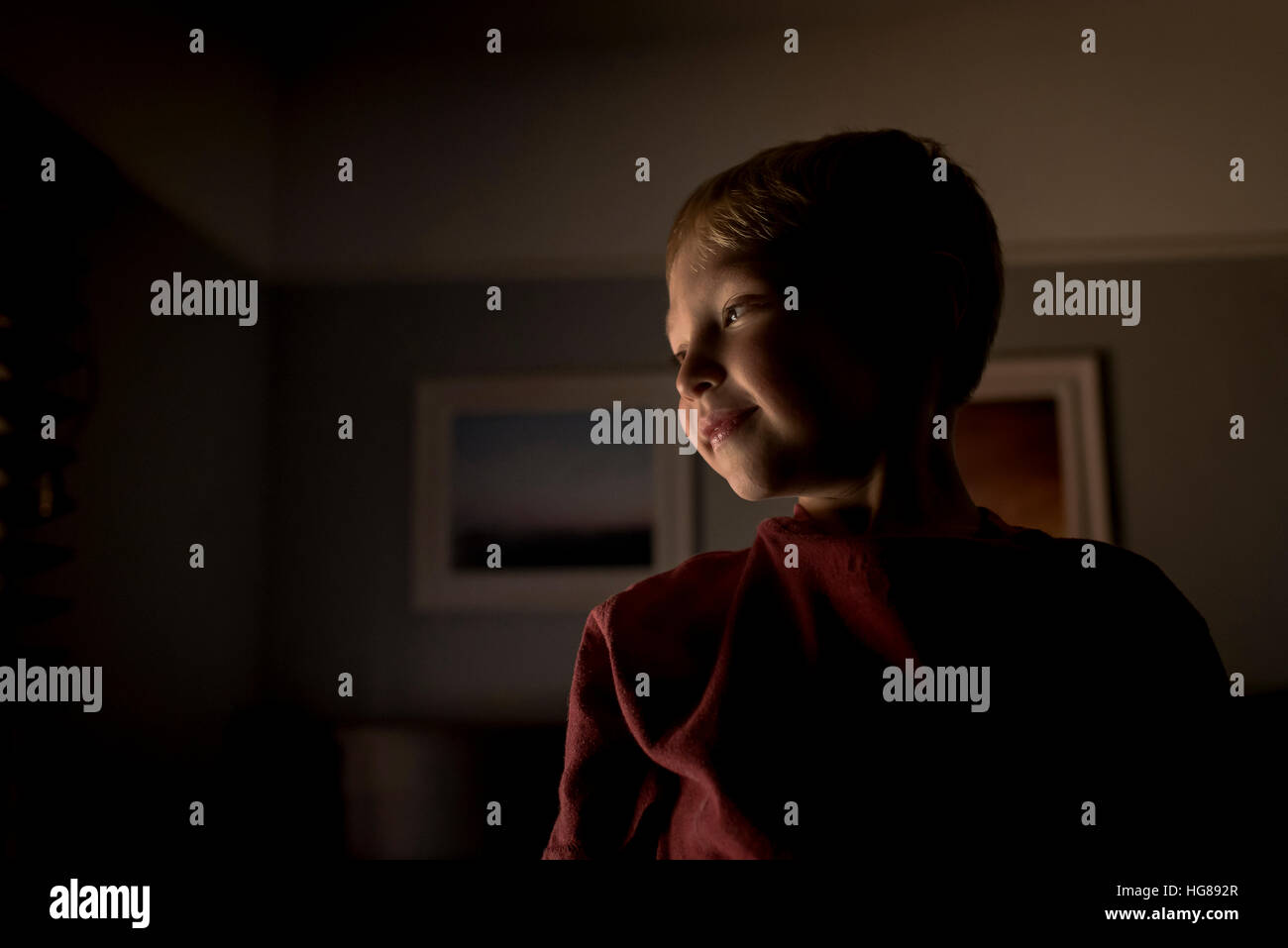 Smiling boy looking over shoulder Stock Photo - Alamy