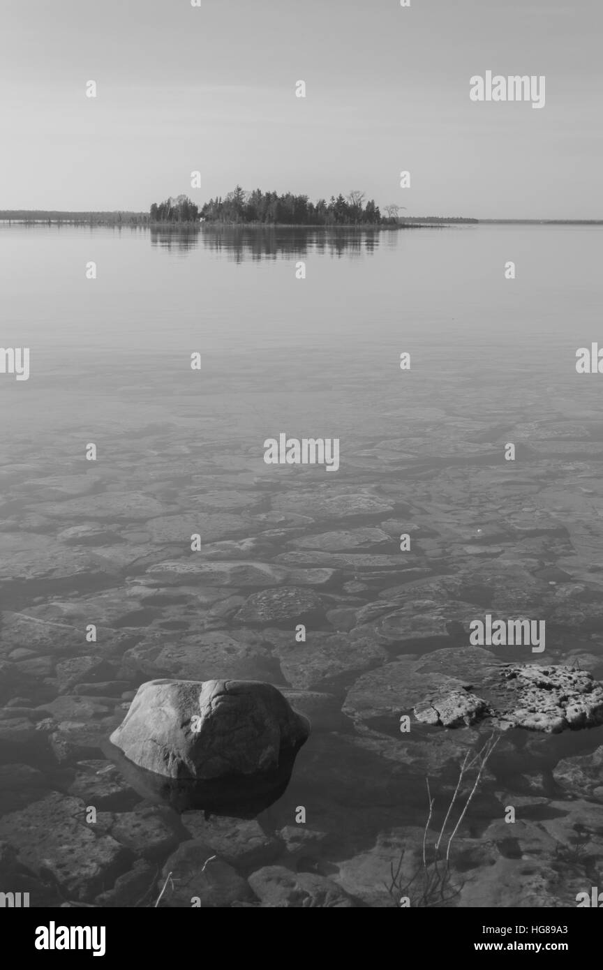 Dead calm image of shallow, clear lake huron water and limestone rocks ...