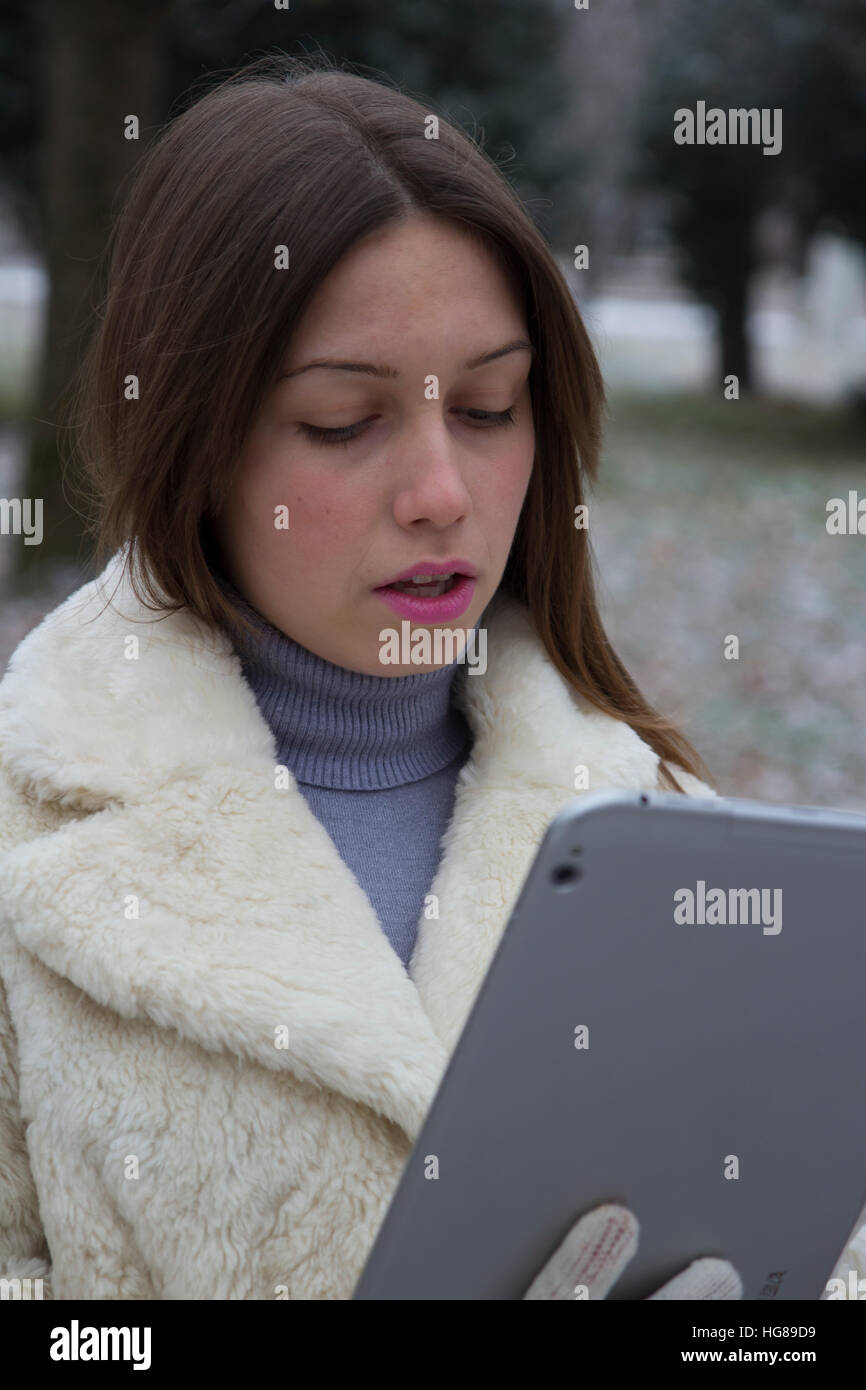 young girl in the park looking at tablet Stock Photo - Alamy