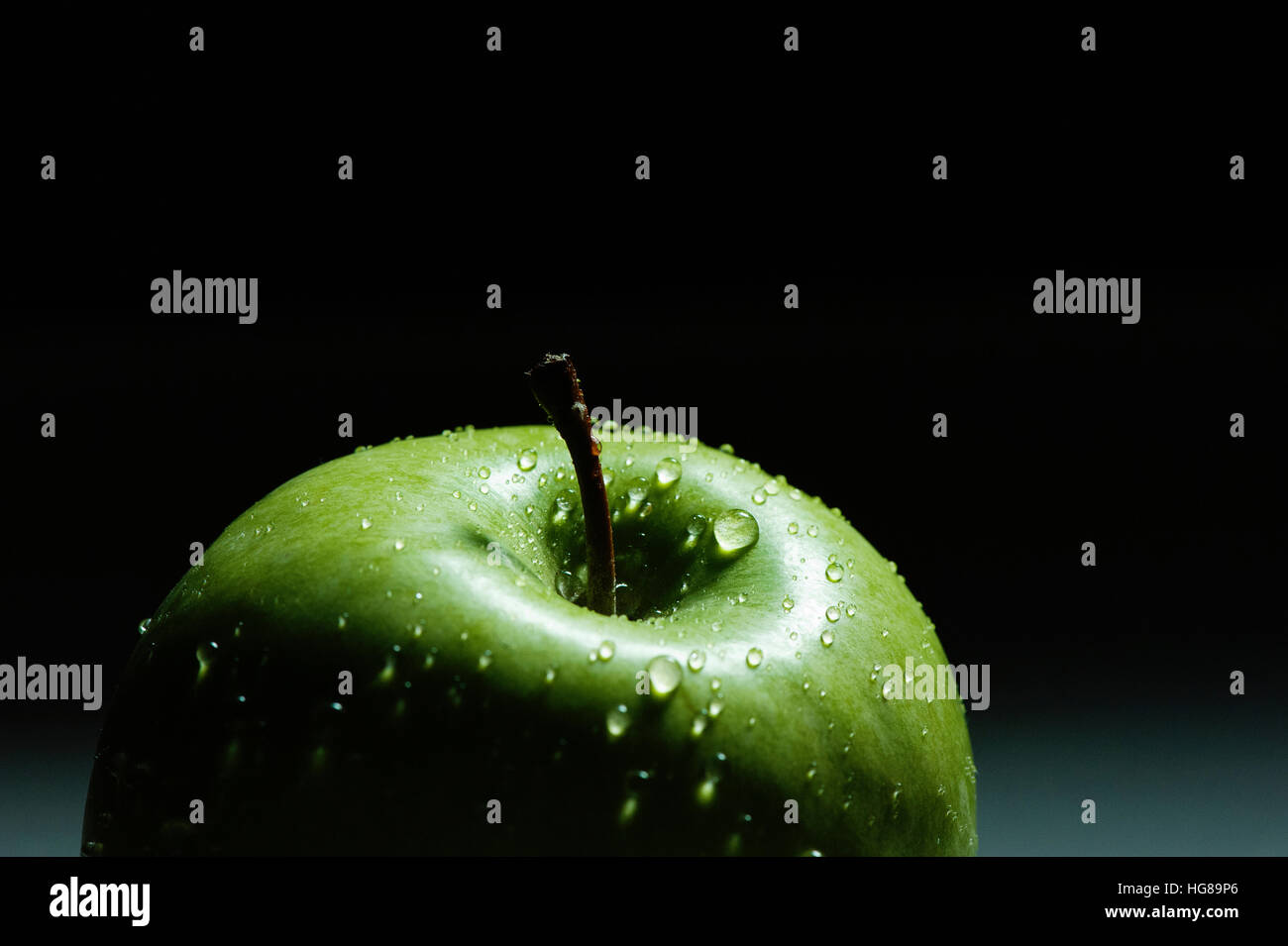 Close-up of wet green apple against black background Stock Photo - Alamy
