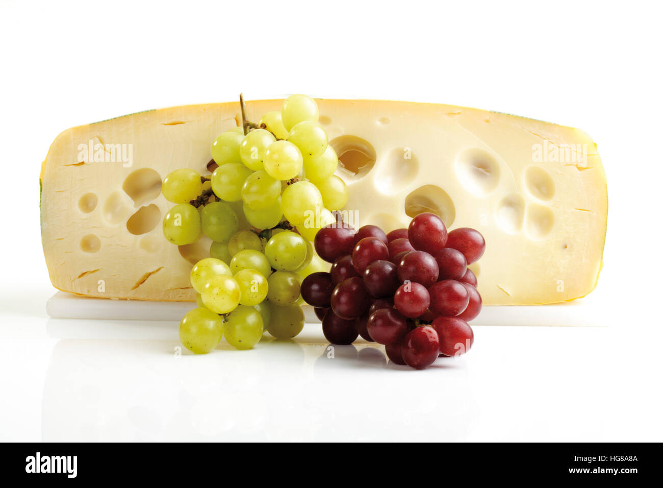 Half cheese wheel with red and green grapes Stock Photo - Alamy