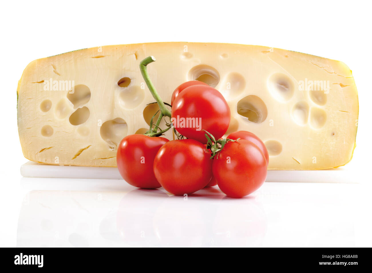 Half cheese wheel with tomatoes Stock Photo - Alamy