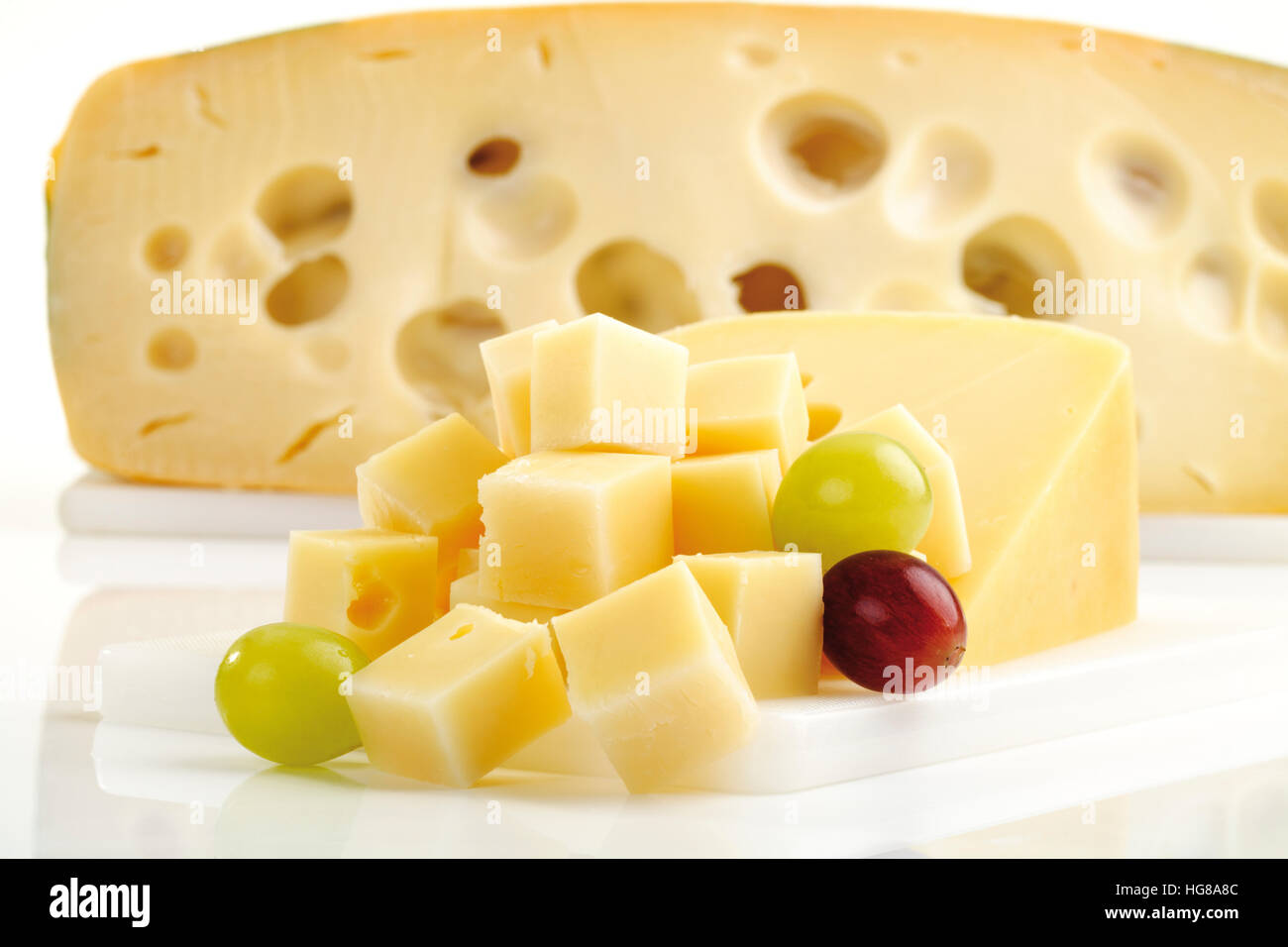 Half cheese wheel, diced cheese and grapes Stock Photo - Alamy