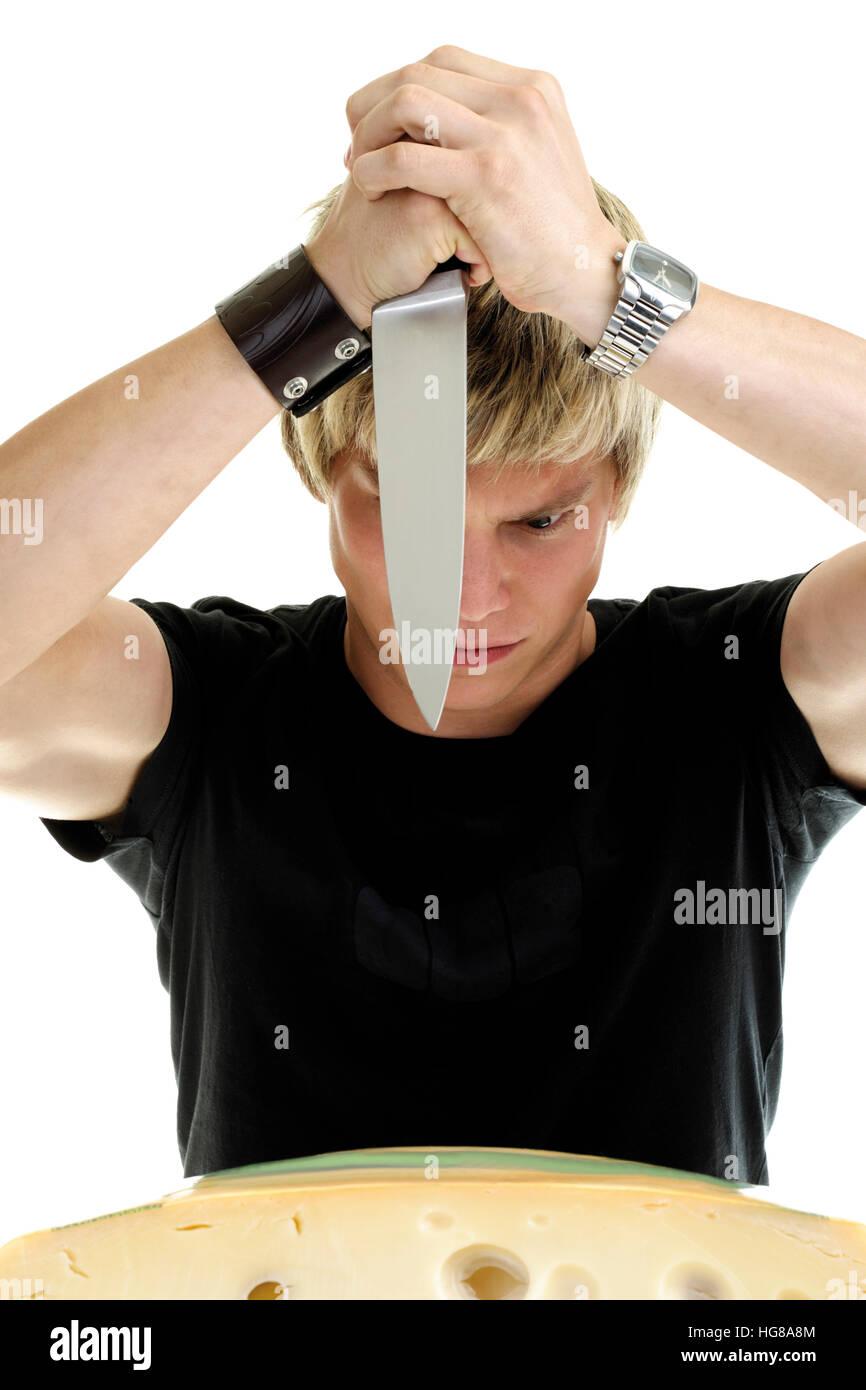 In-your-face guy: young man stabbing into cheese wheel Stock Photo - Alamy