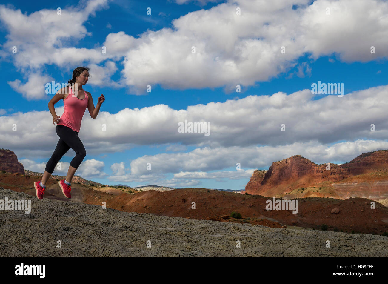 Athlete running on rock formations against cloudy sky Stock Photo - Alamy