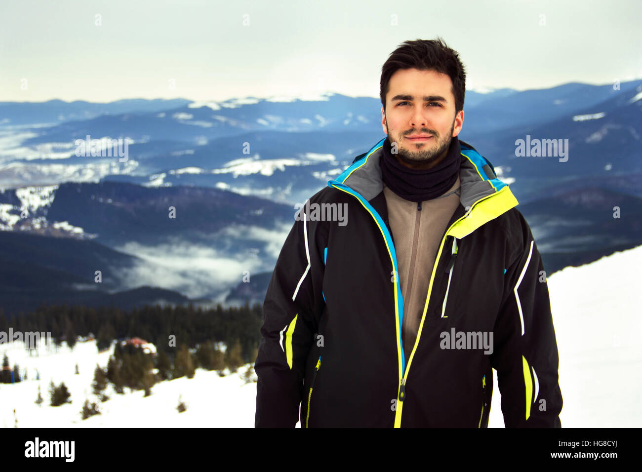 A young man standing on a snowy mountain Stock Photo - Alamy