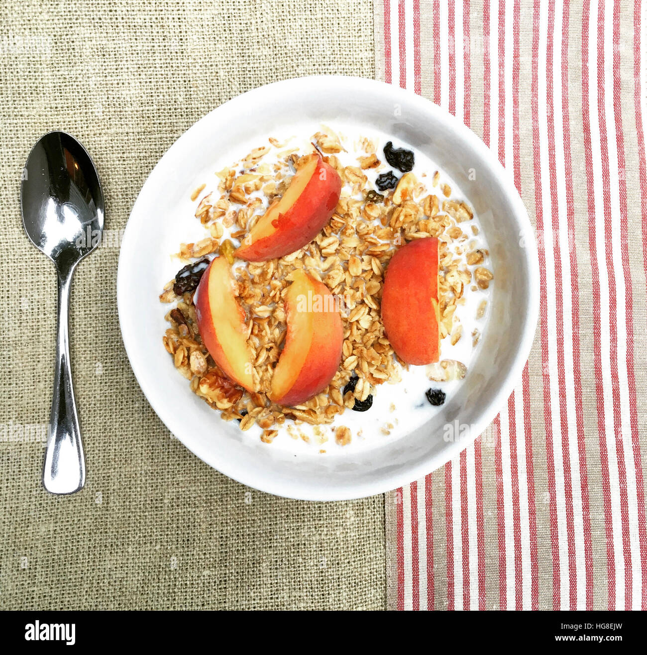 Overhead view of breakfast cereal garnished with peach slices in bowl ...