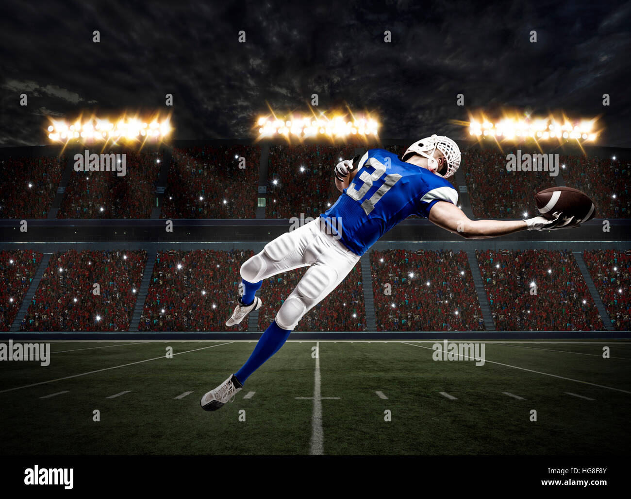Football Player with a blue uniform catching a ball on a stadium Stock ...