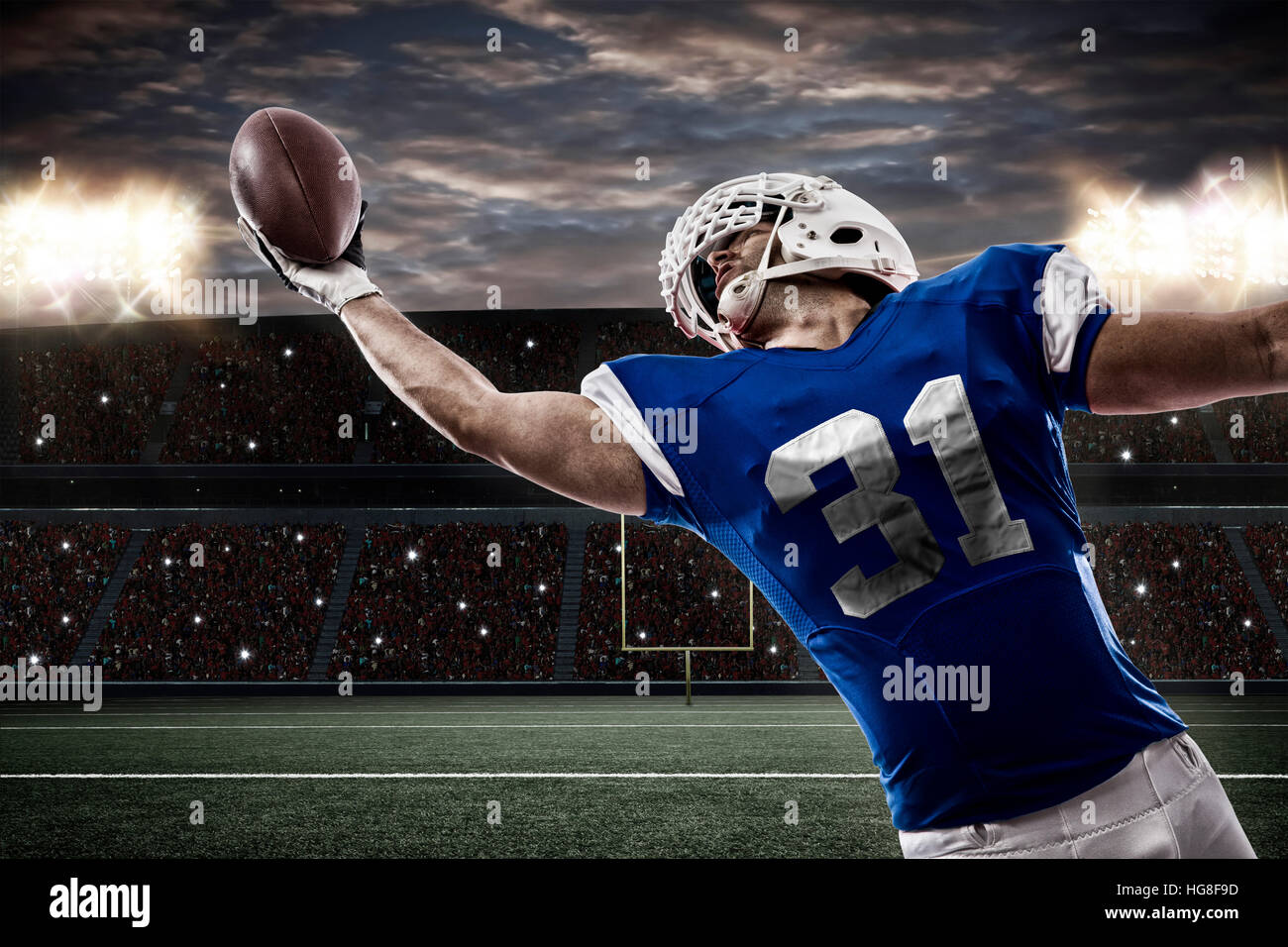 Football Player with a blue uniform catching a ball on a stadium Stock ...