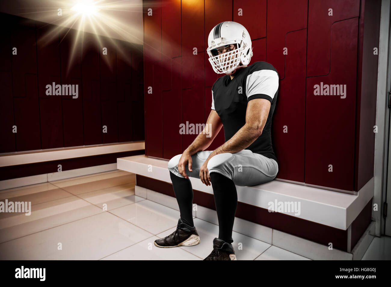 Football Player with a Black uniform seated in locker room Stock Photo ...