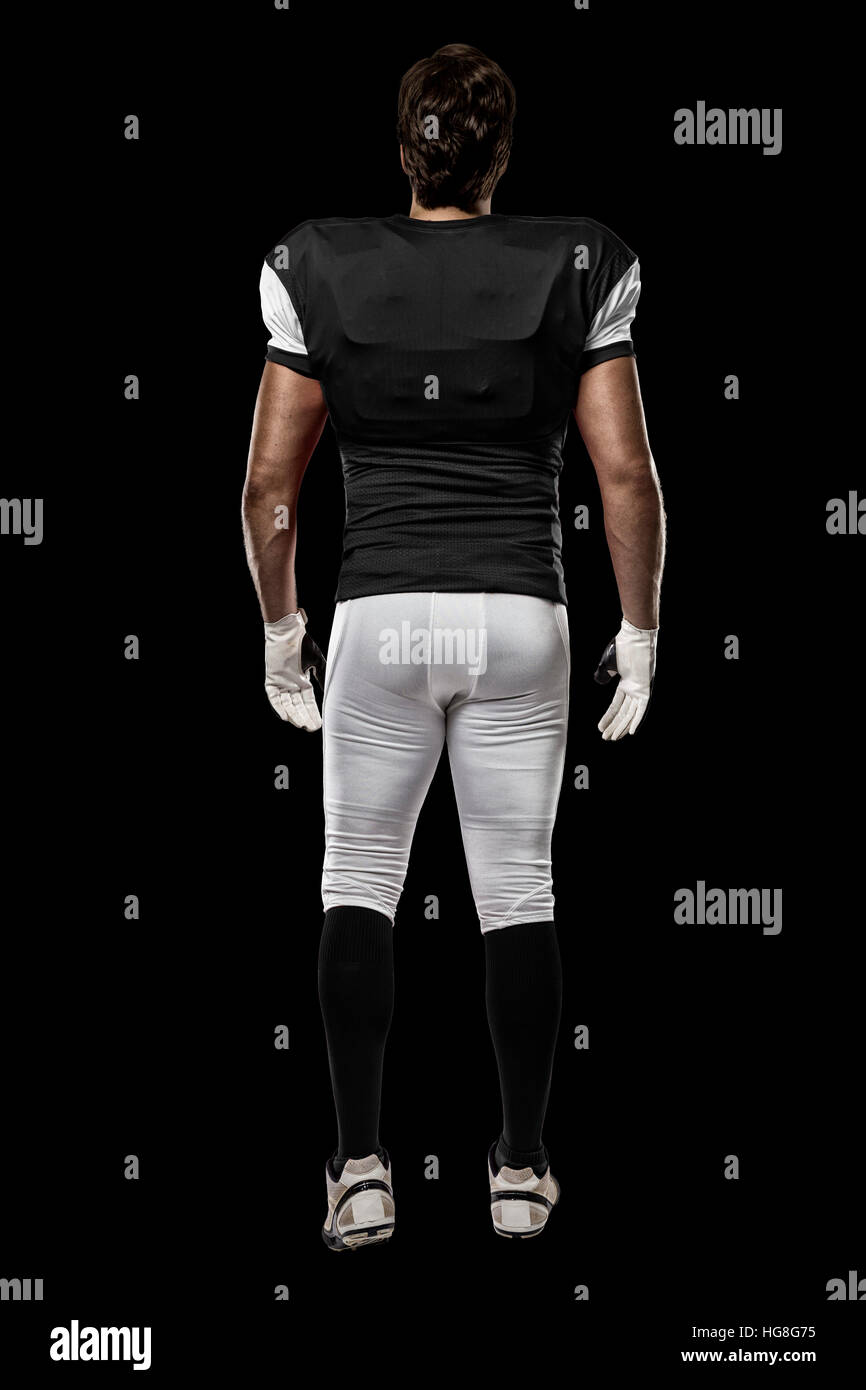 Football Player with a black uniform walking, showing his back on a ...