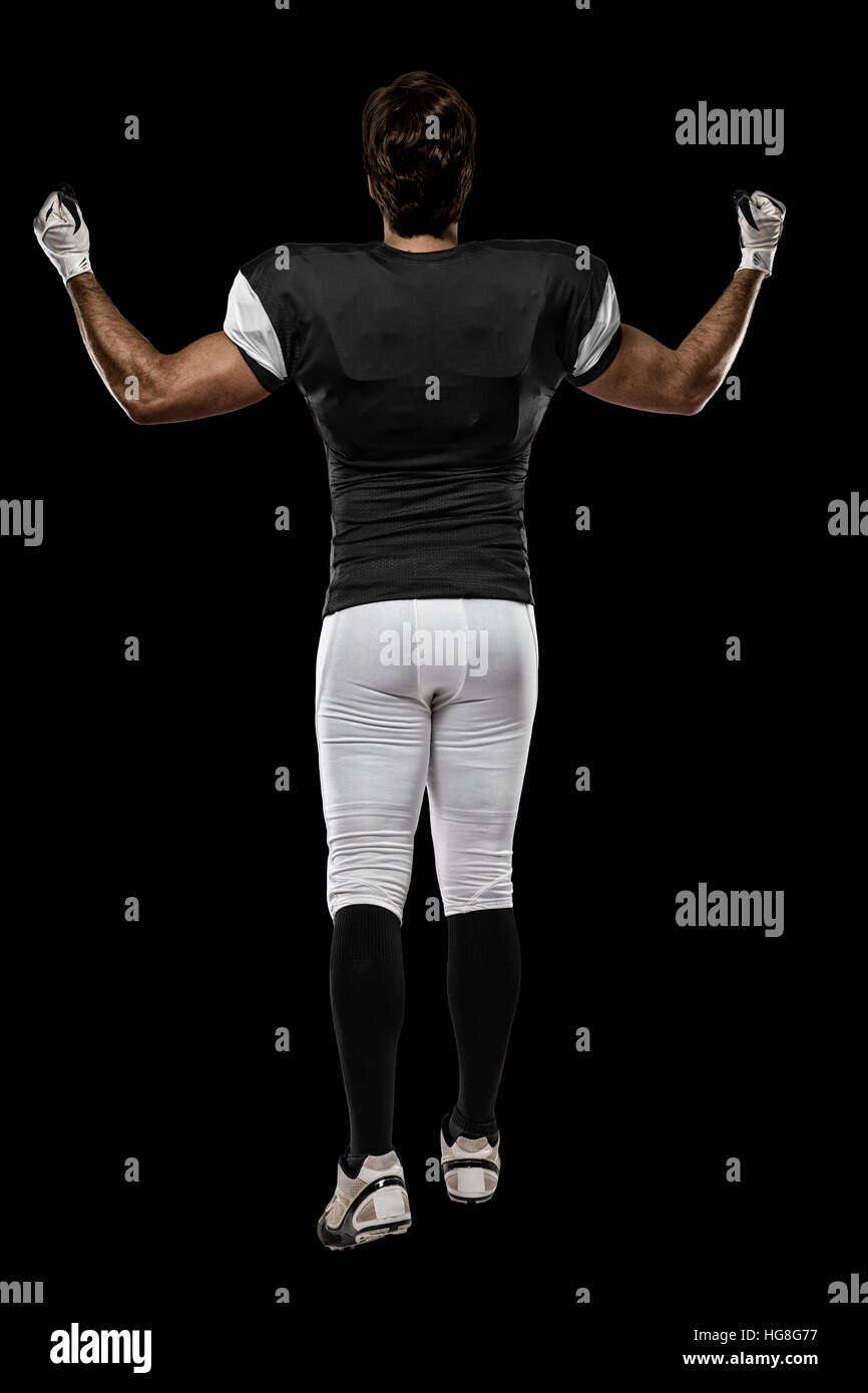 Football Player with a black uniform walking, showing his back on a ...