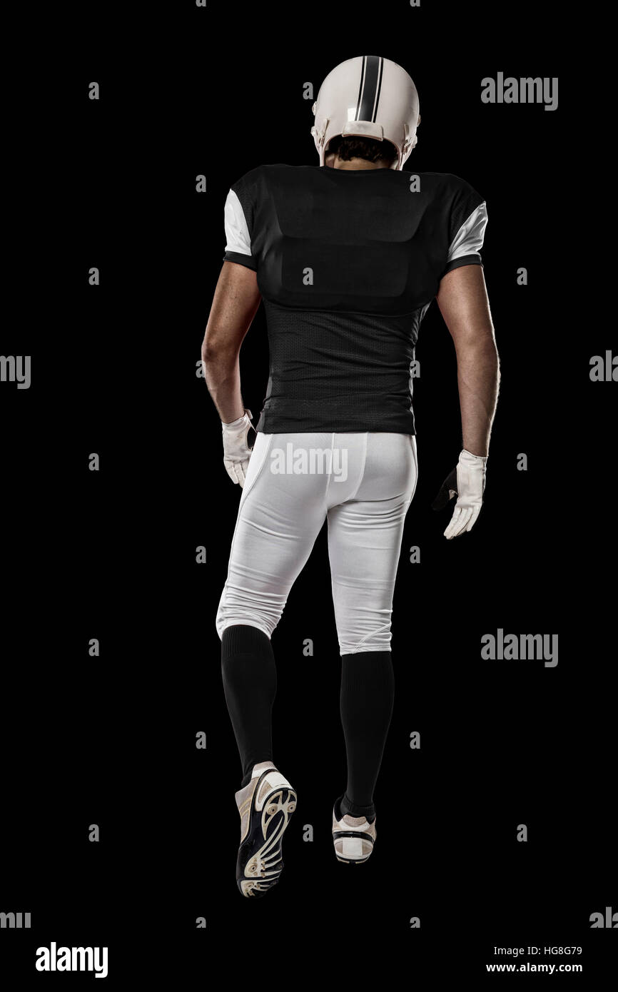 Football Player with a black uniform walking, showing his back on a ...