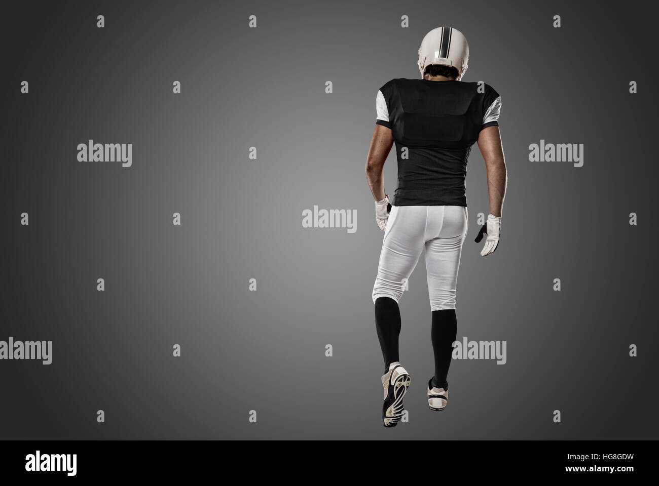 Football Player with a black uniform walking, showing his back on a ...