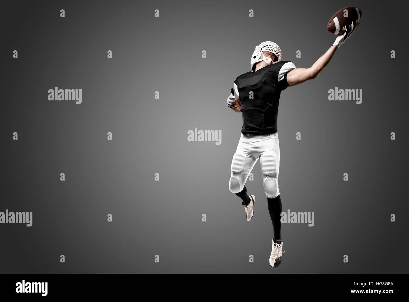 Football Player with a black uniform making a catch on a black ...