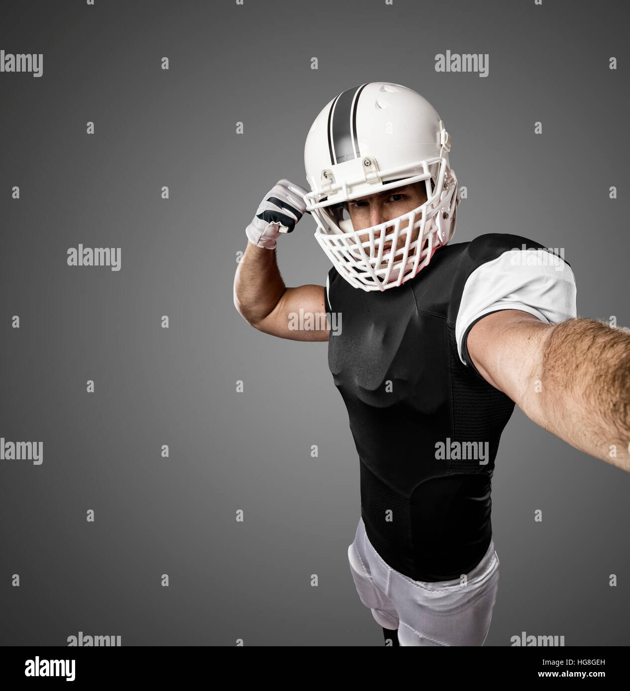 Football Player with a black uniform making a selfie on a black ...