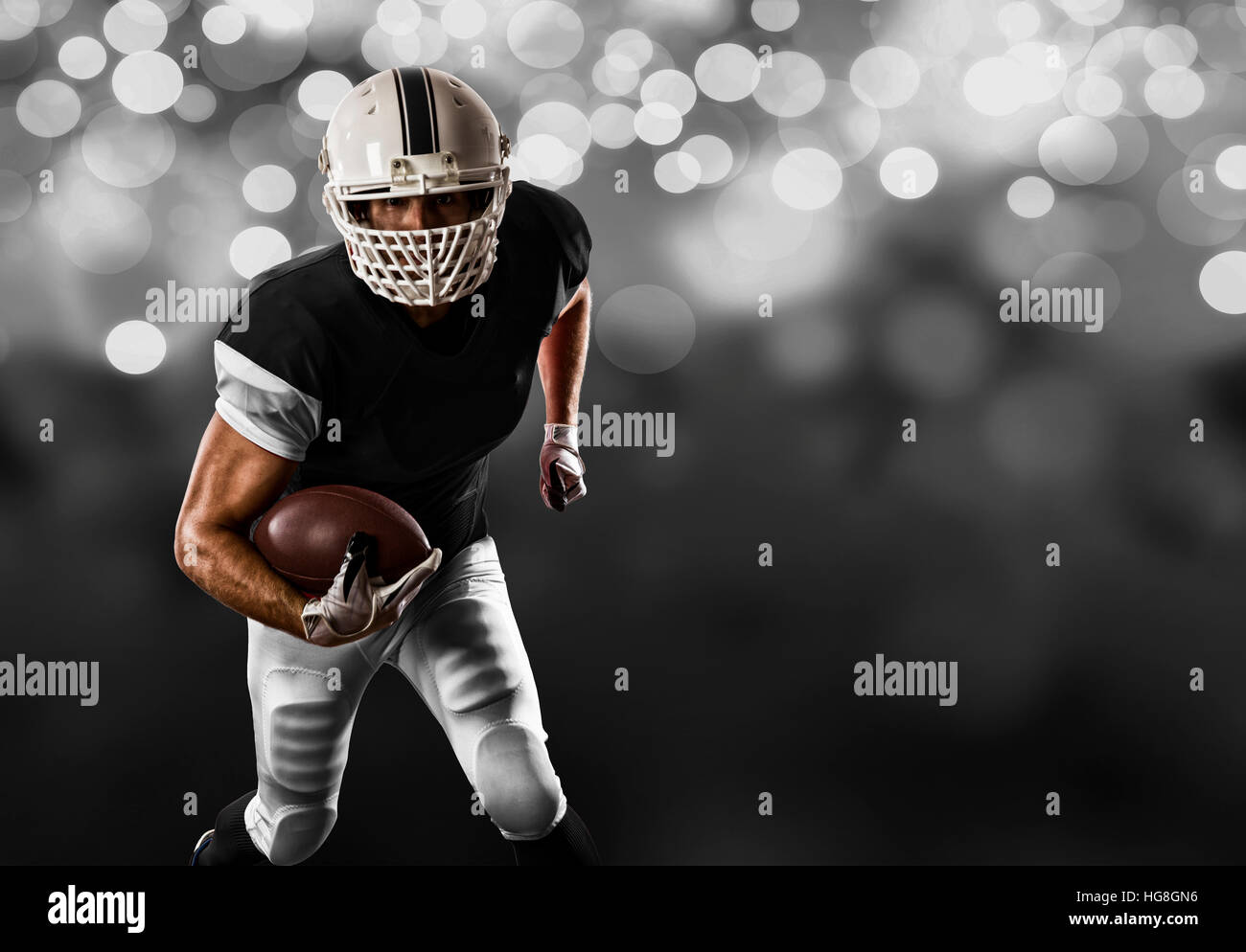 Football Player with a black uniform Running on a black lights ...