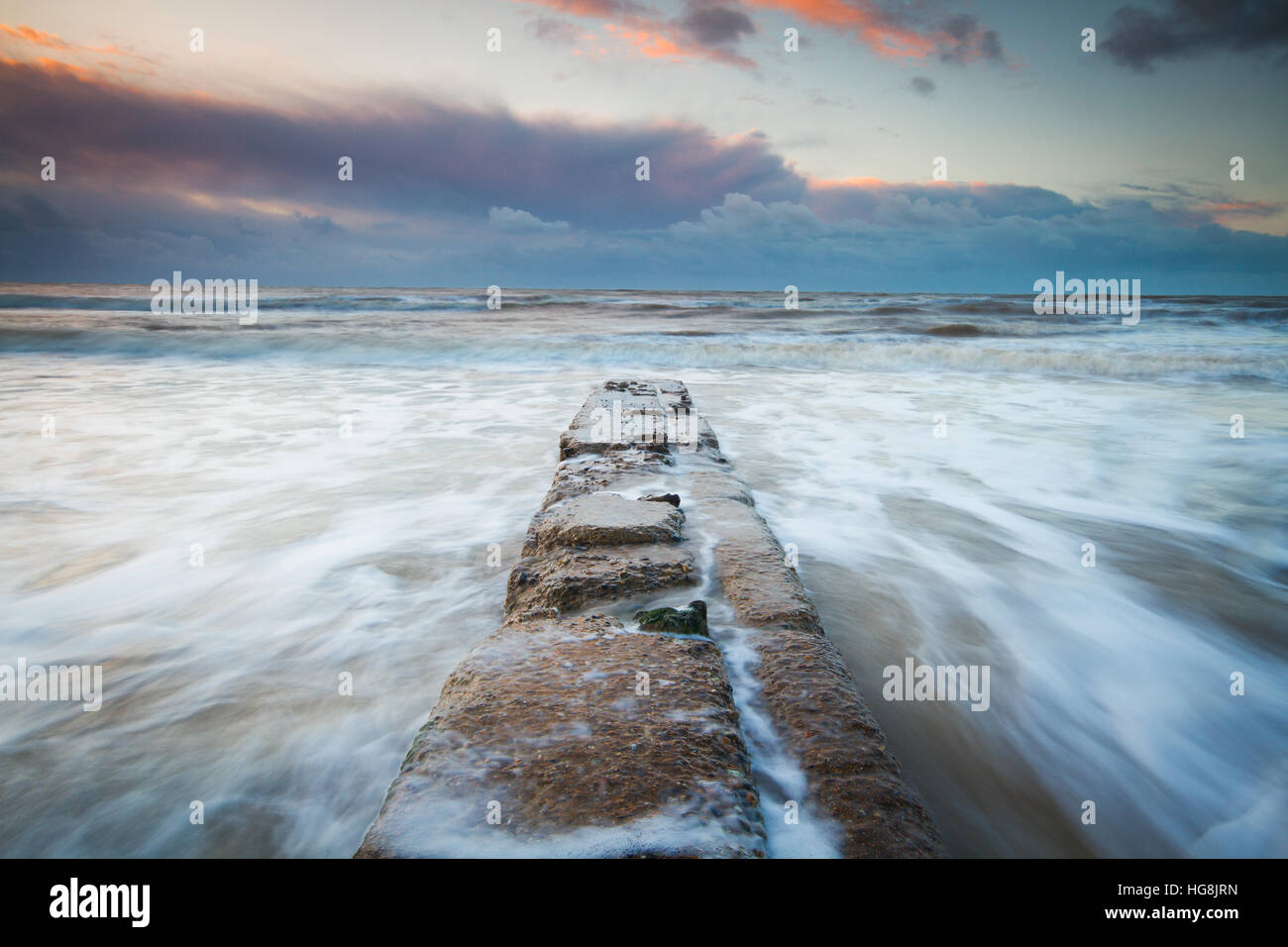 Path leading out to the open ocean during sunrise Stock Photo - Alamy