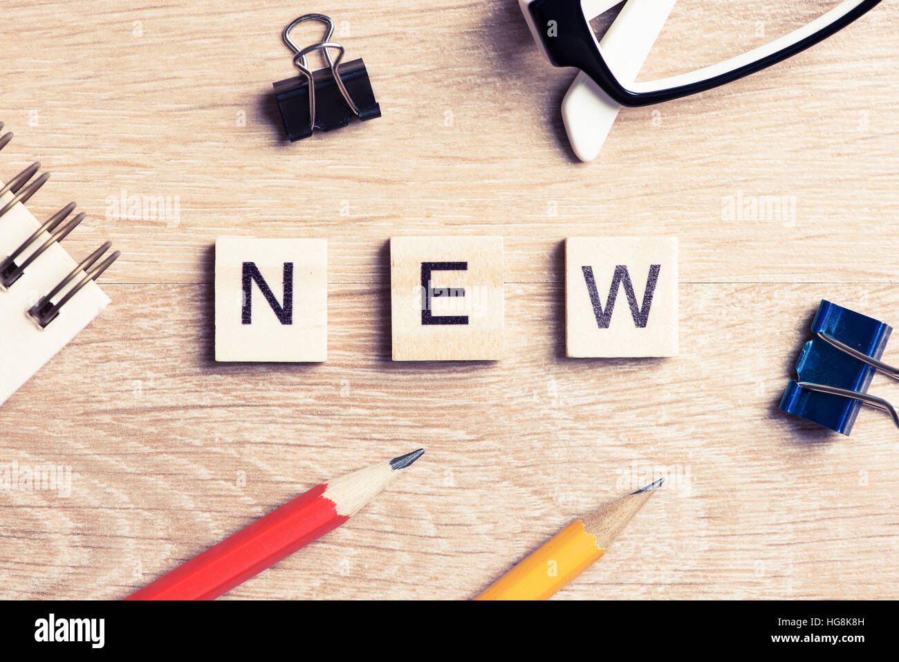 Game elements on wooden table spelling word new Stock Photo - Alamy