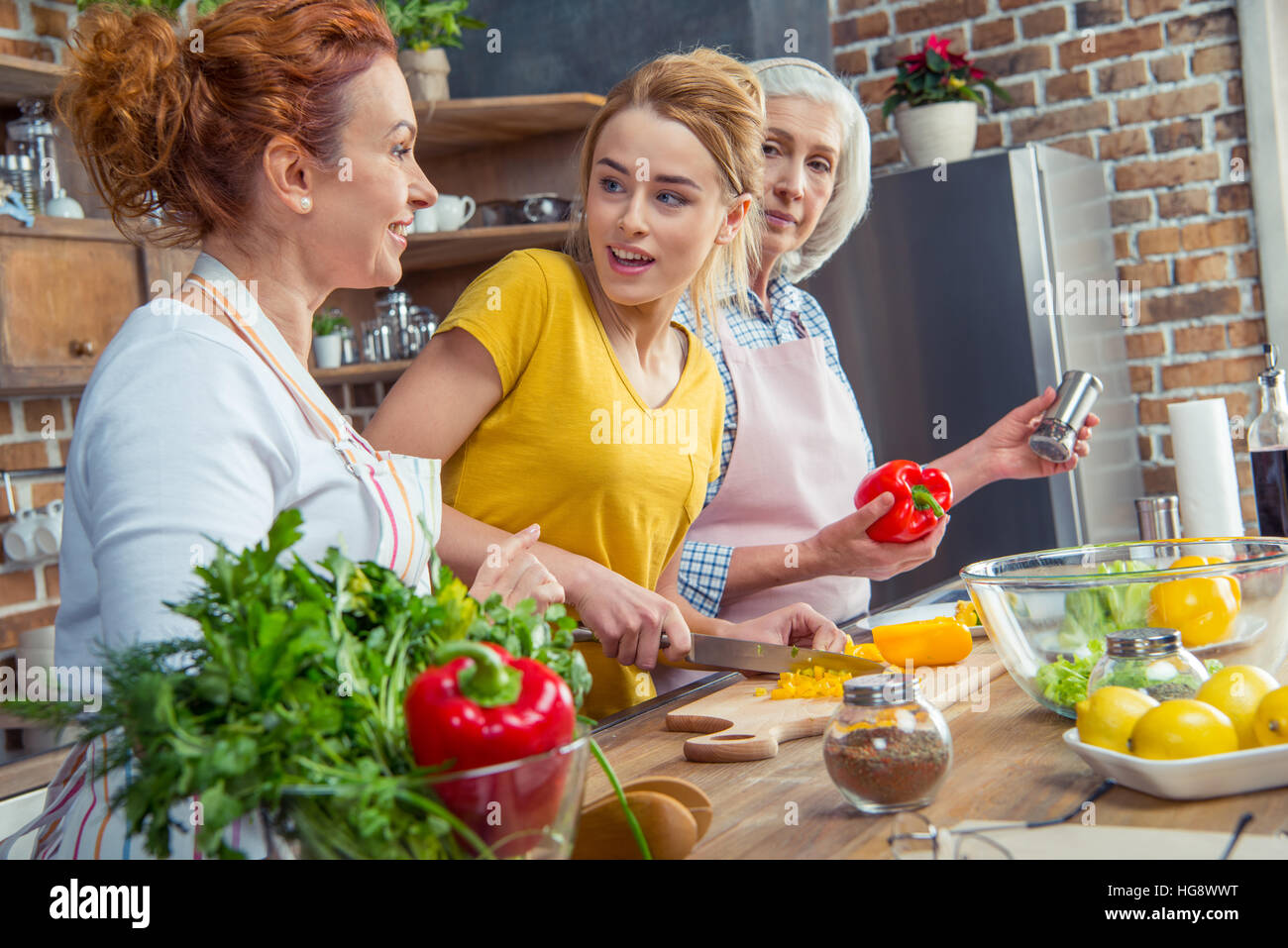 Happy three-generation family cooking together vegetable salad in ...