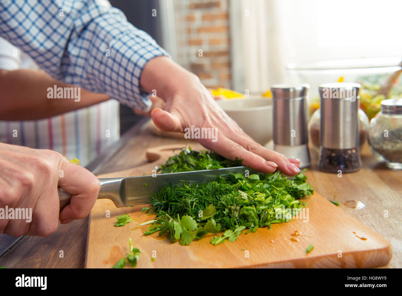 Close-up partial view of woman cutting salad greens Stock Photo - Alamy