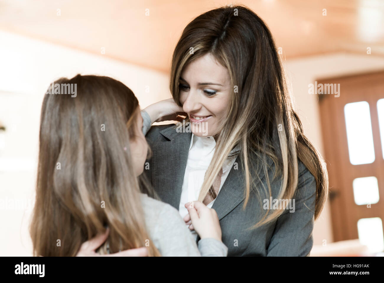 Mother embracing her little girl before leaving to work/or just back ...