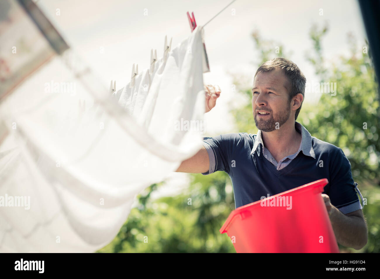 Young man hanging up laundry Stock Photo - Alamy