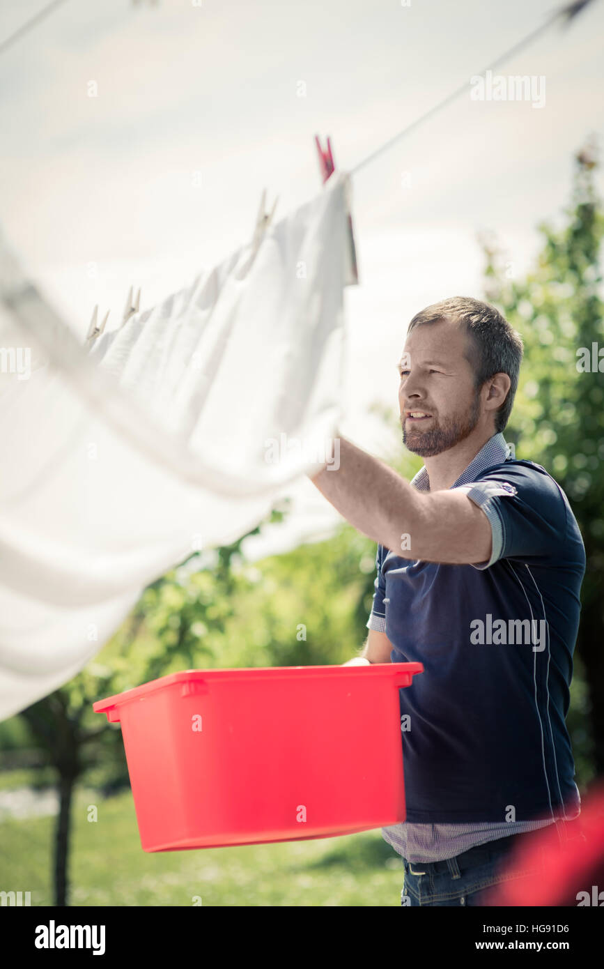 Man hanging clothes hi-res stock photography and images - Alamy