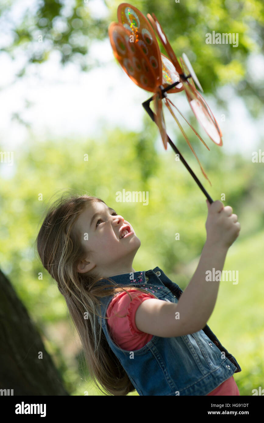 Little girl playing with pinwheel Stock Photo - Alamy