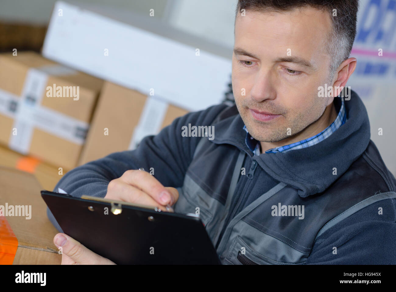 happy delivery man with clipboard in the warehouse Stock Photo - Alamy