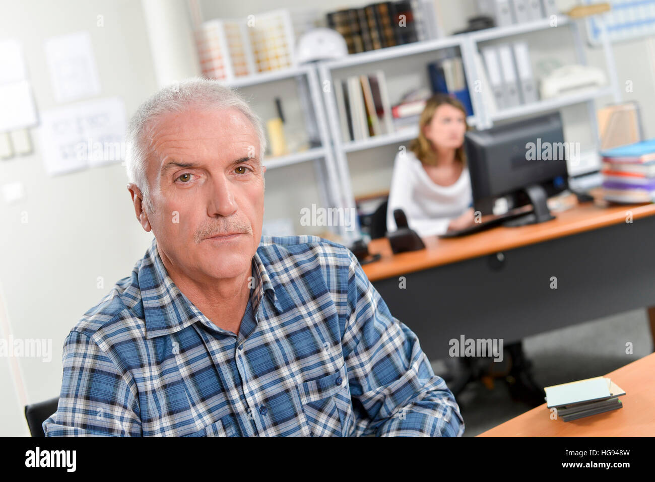 Senior man sat at his desk Stock Photo - Alamy