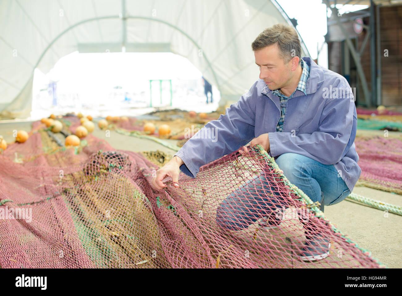 fixing the fishing net Stock Photo - Alamy