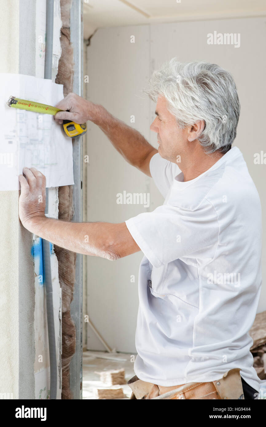 Man measuring plans Stock Photo - Alamy