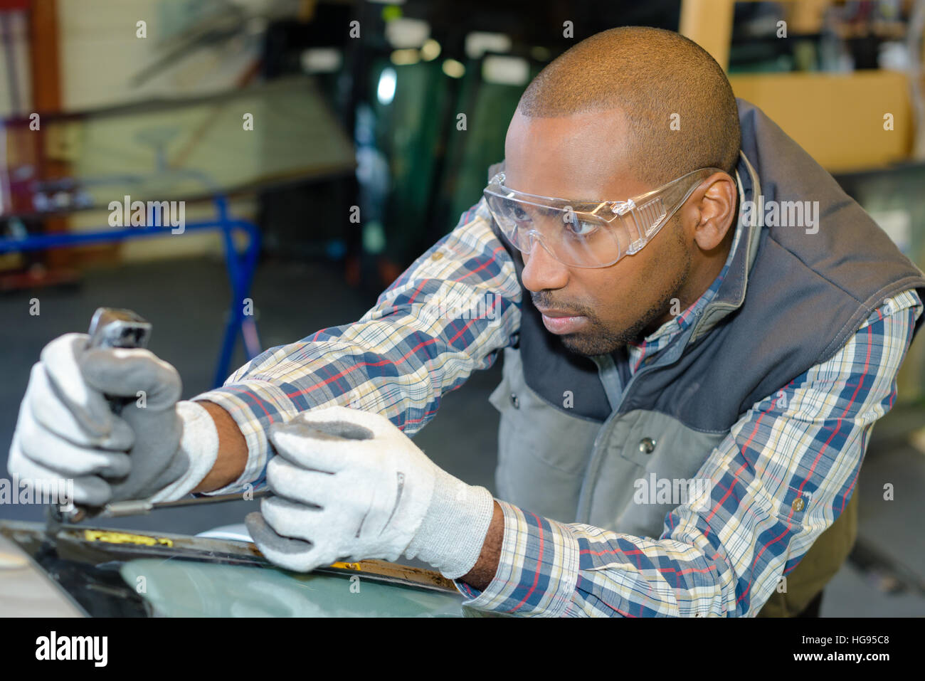 Male worker using tool to fit windshield Stock Photo - Alamy