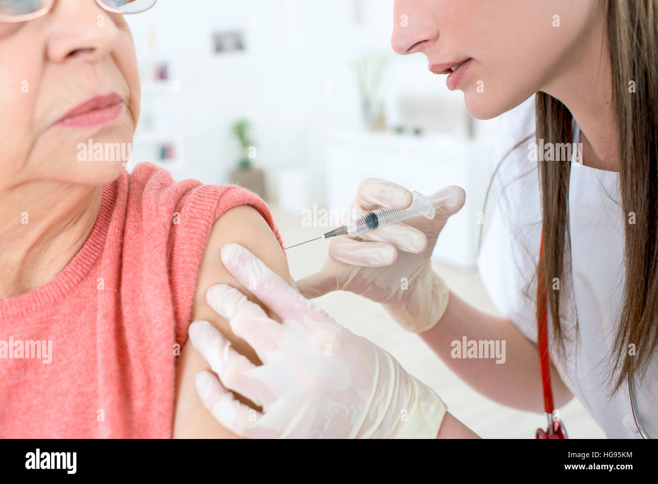 Injection in her shoulder Stock Photo - Alamy