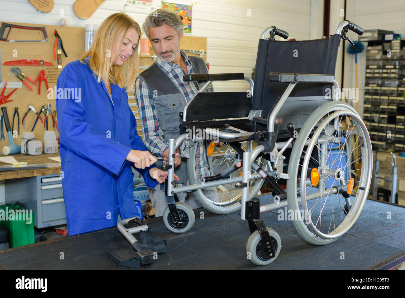 Man and woman with wheelchair on workshop bench Stock Photo - Alamy
