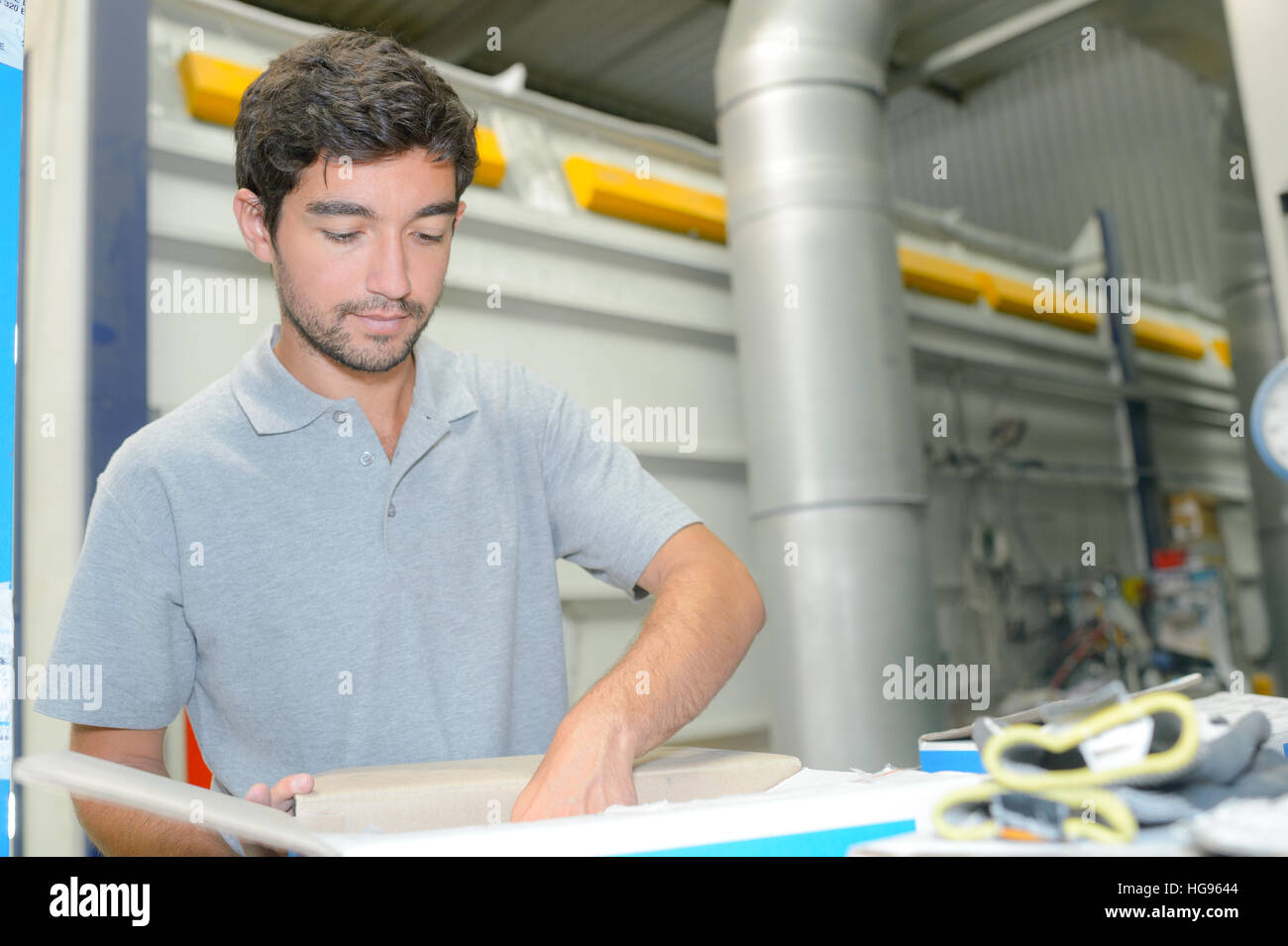 Factory worker with his hand in a box Stock Photo - Alamy