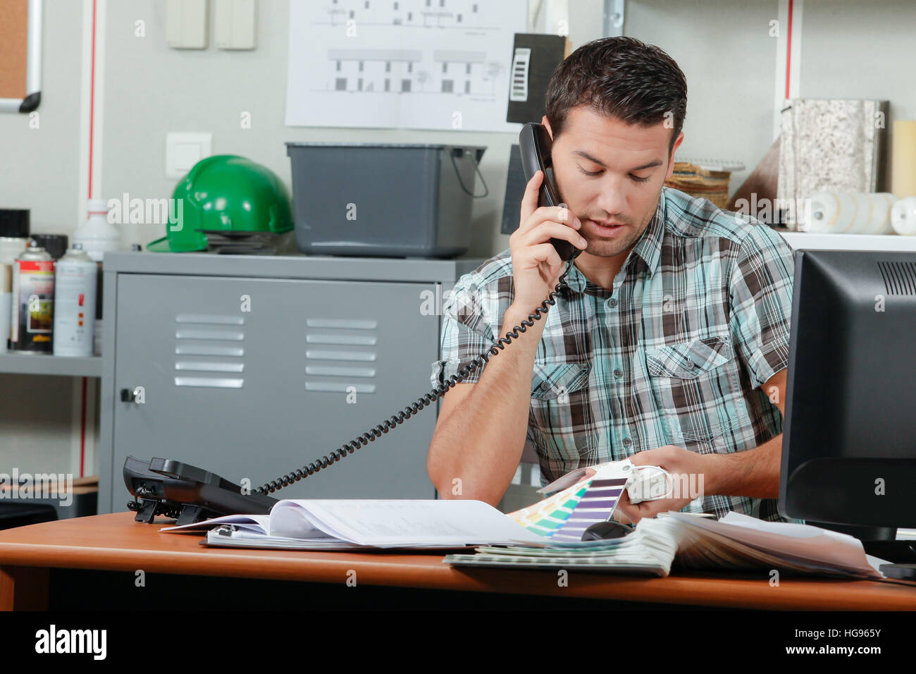 Man on telephone looking at color charts Stock Photo - Alamy