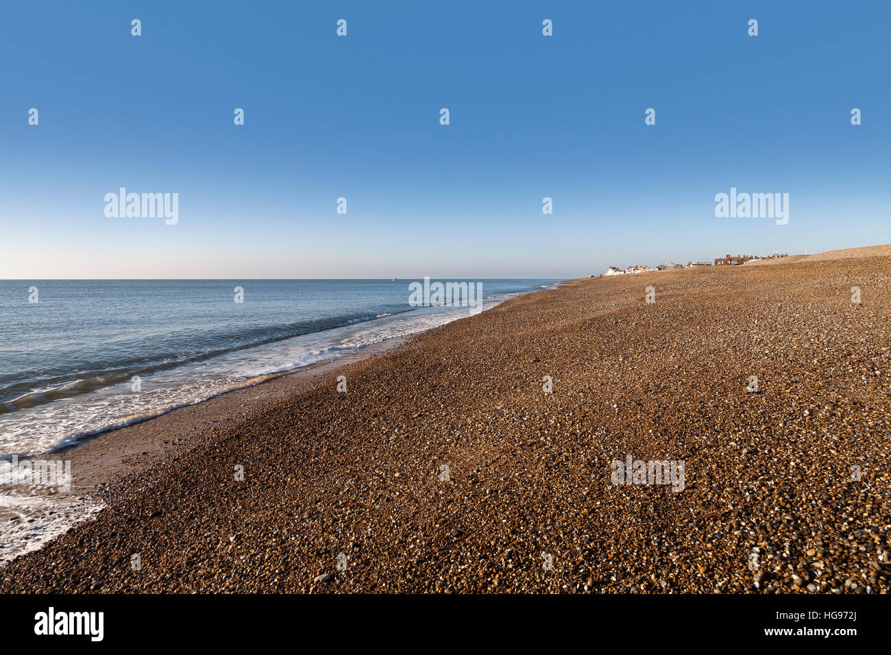 A long expanse of shingle beach with the seaside town of Aldeburgh ...