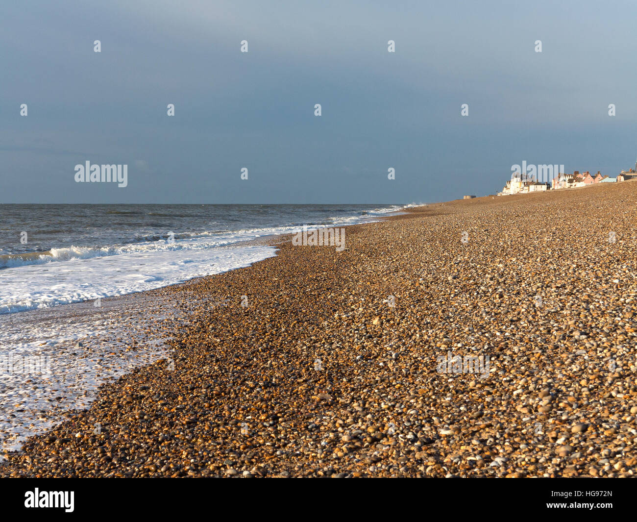 A long expanse of shingle beach with the seaside town of Aldeburgh ...