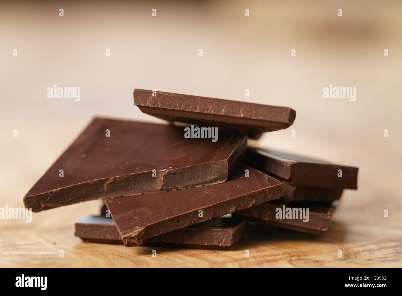 stacked pieces of chocolate bar on wooden table Stock Photo - Alamy