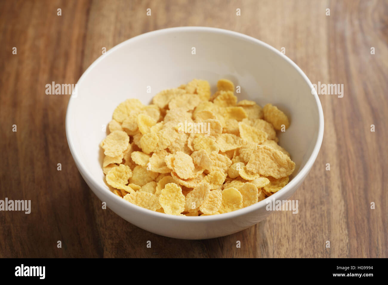 dry corn flakes in white bowl on wood table Stock Photo - Alamy