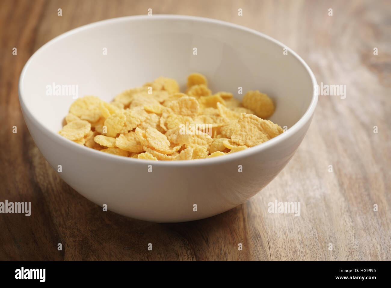 dry corn flakes in white bowl on wood table Stock Photo - Alamy