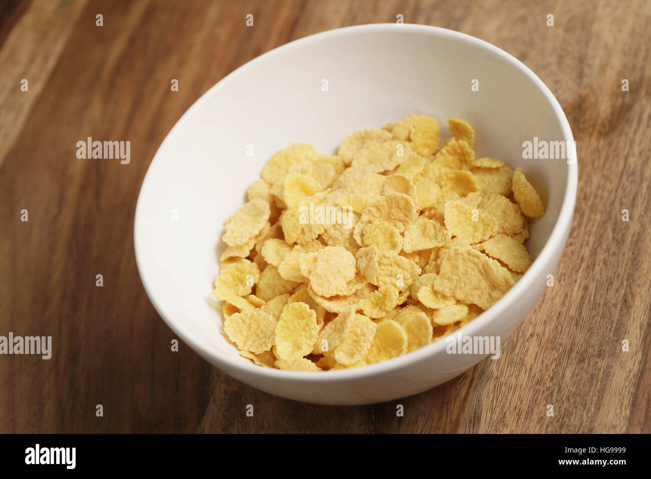 dry corn flakes in white bowl on wood table Stock Photo - Alamy