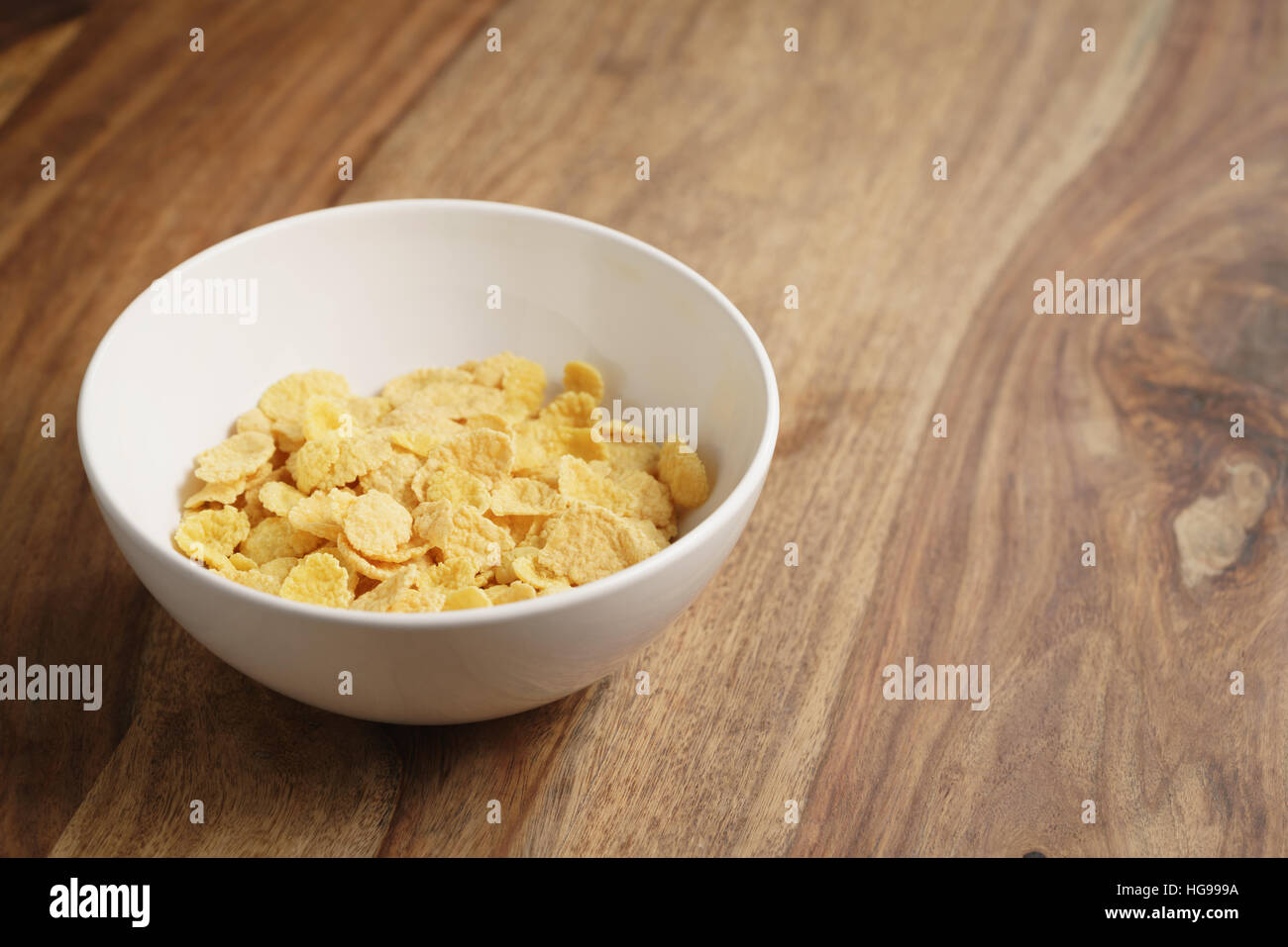 dry corn flakes in white bowl on wood table Stock Photo - Alamy