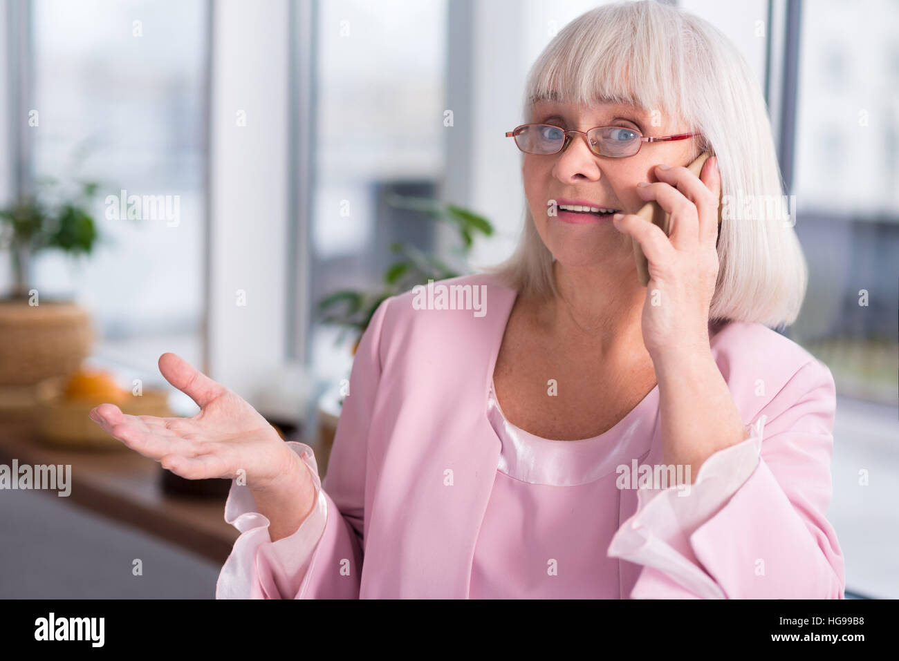 Expressive businesswoman calling someone Stock Photo - Alamy