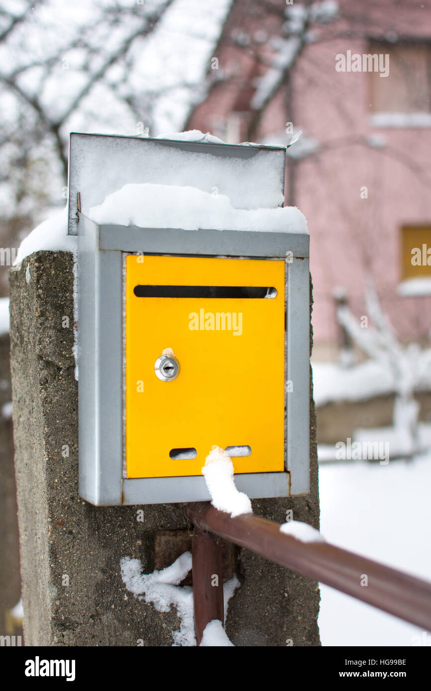 Snow covered yellow mailbox in front of a house Stock Photo - Alamy