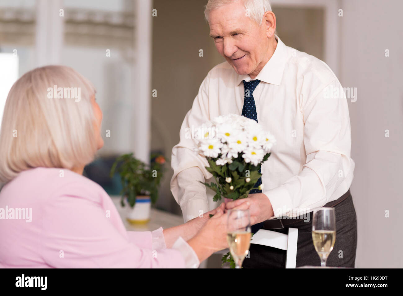 Gallant handsome man giving flowers Stock Photo - Alamy