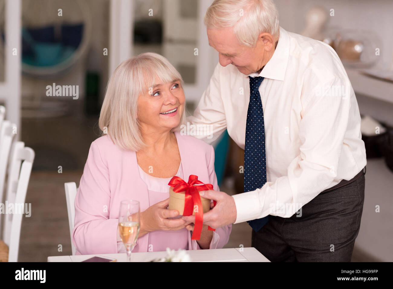 Delighted elderly woman holding a present Stock Photo - Alamy