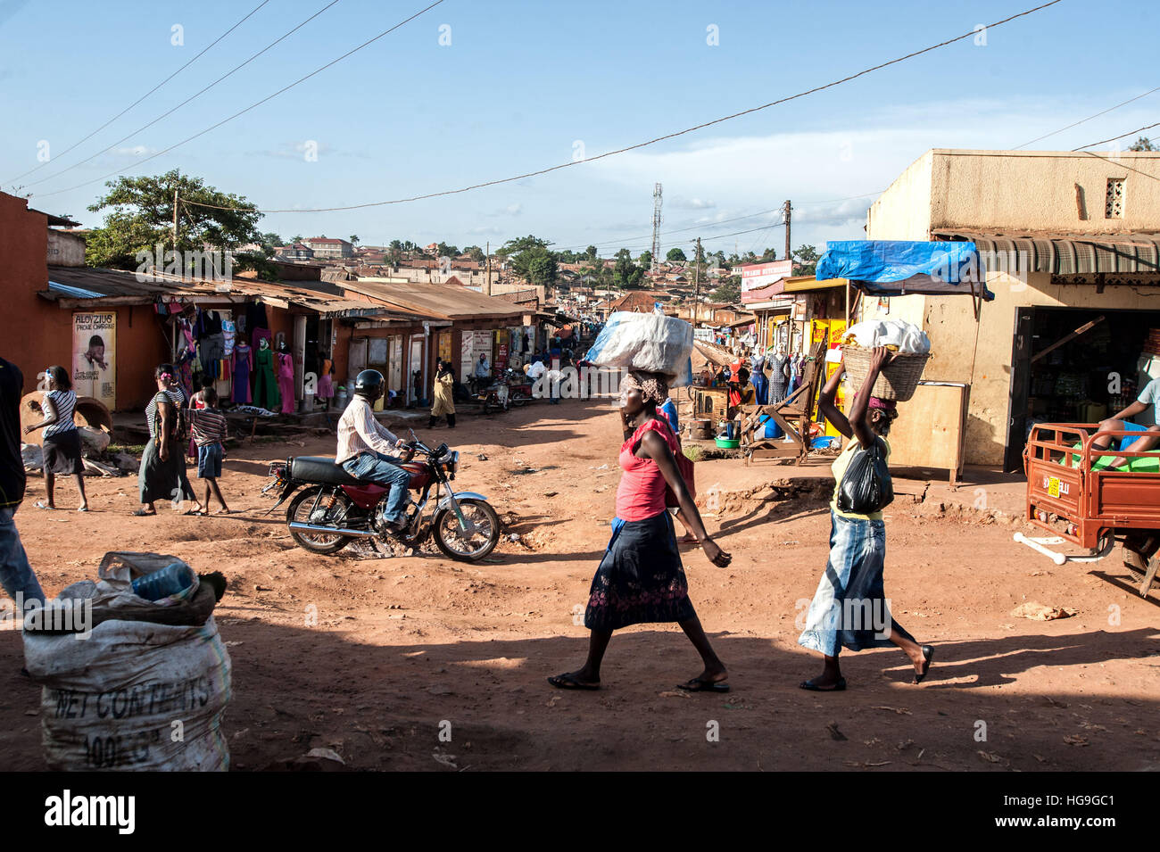 Residents walk through the streets of Katwe slum, Uganda Stock Photo ...